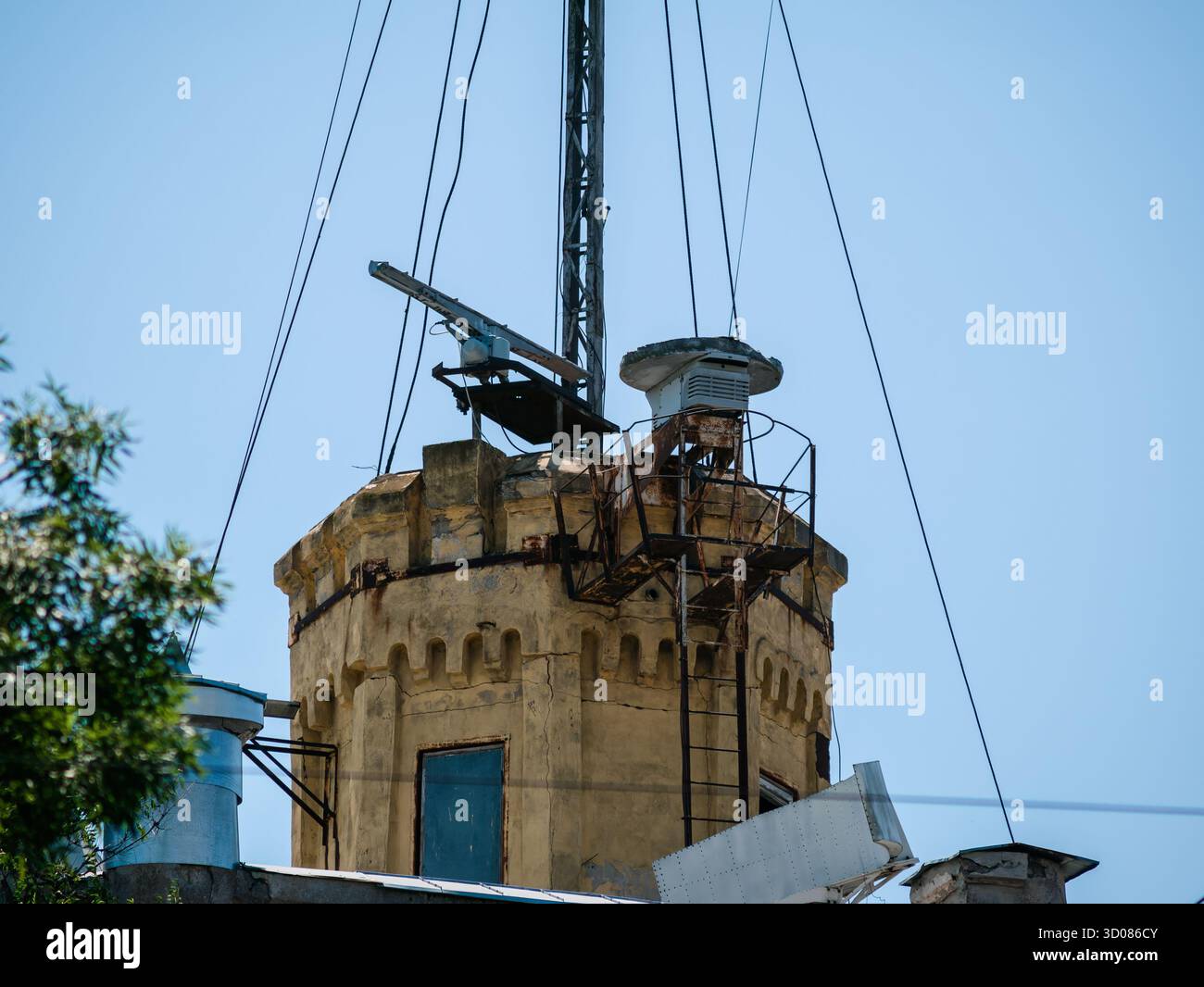 A radar antenna mounted on the roof of an old tower, standing clearly ...