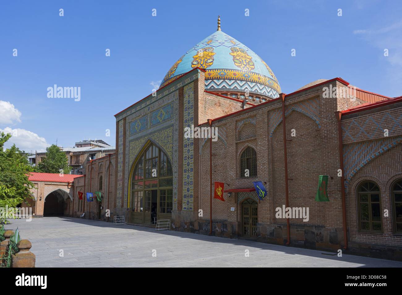 Side view of a mosque with blue dome and colorful mosaics under bright ...