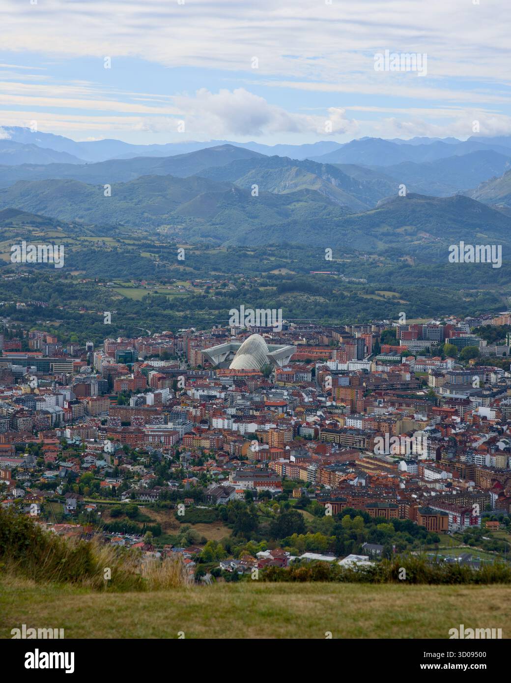 City overview with modern architecture surrounded by mountain landscape ...