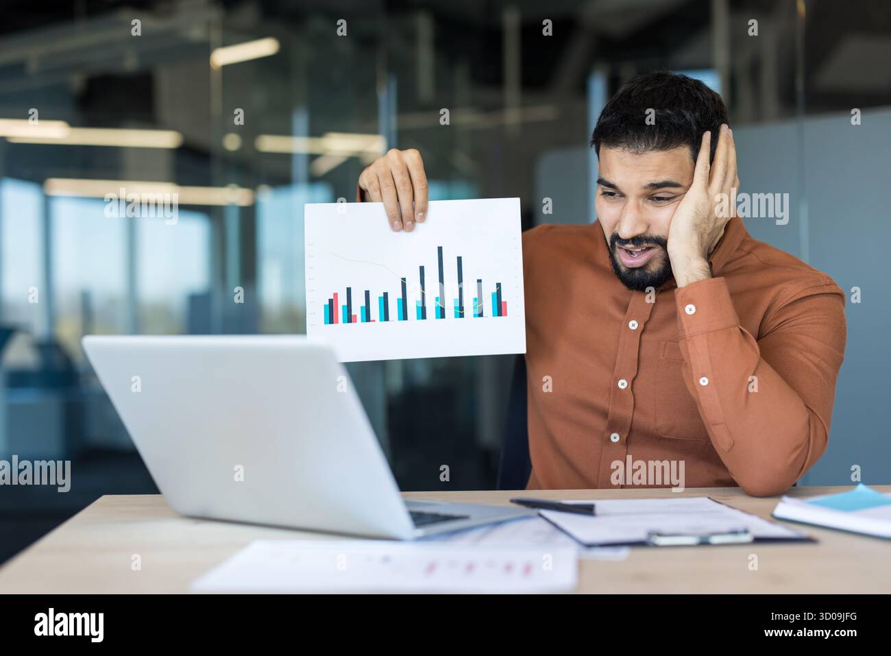 Stressed businessman on a video call showing a downward sales graph to ...