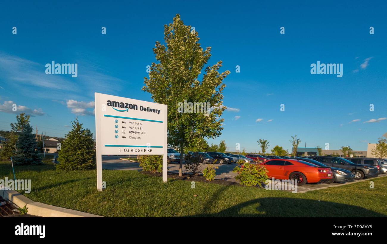 A sign for Amazon delivery is in front of a tree. The sign is white and ...