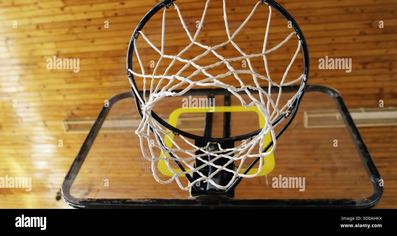 Hanging basketball hoop with white net inside gym, with yellow padding ...