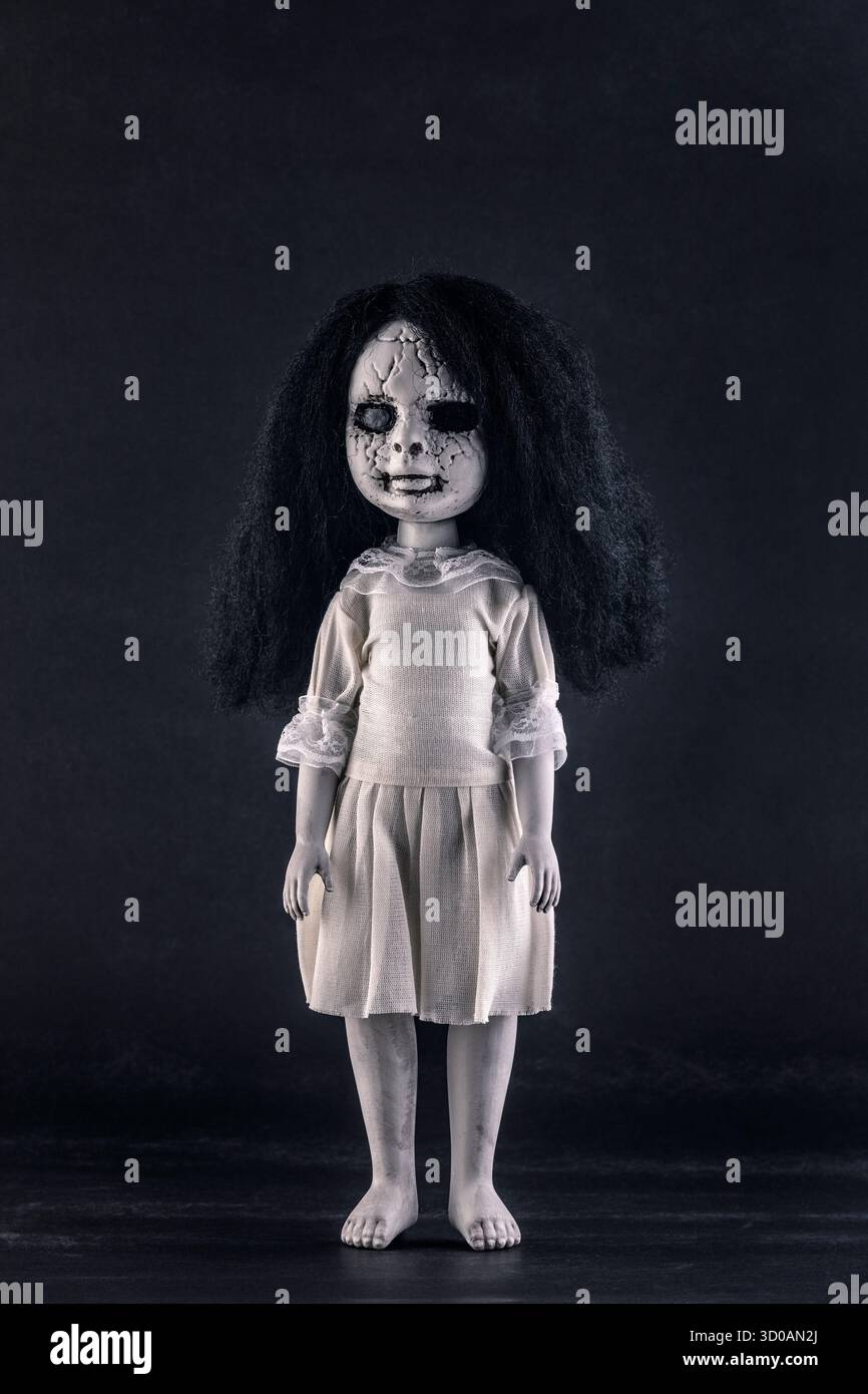 Scary cracked doll with black hair on dark background Stock Photo - Alamy