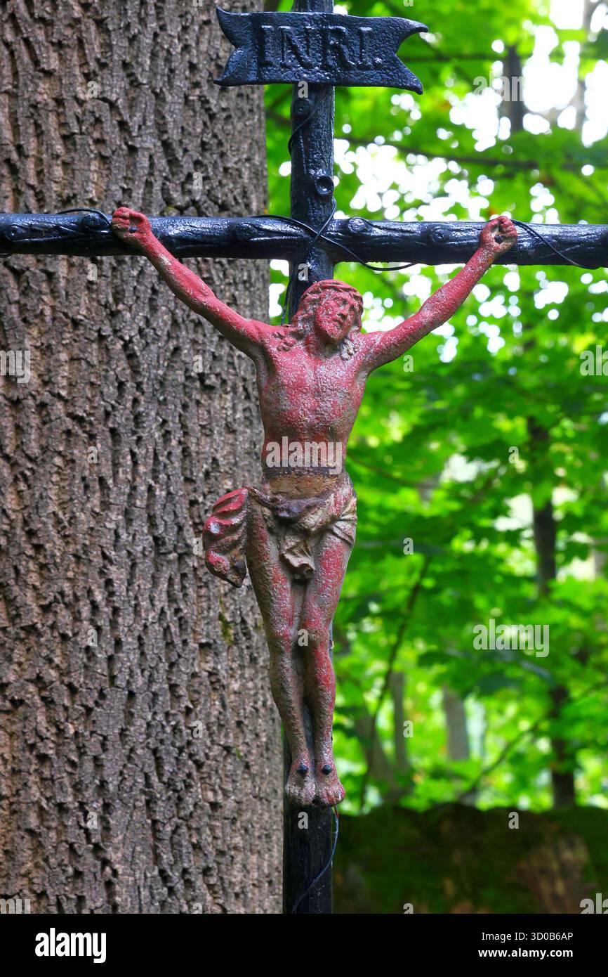 Bloody red cemetery crucifix in a forest setting Stock Photo - Alamy