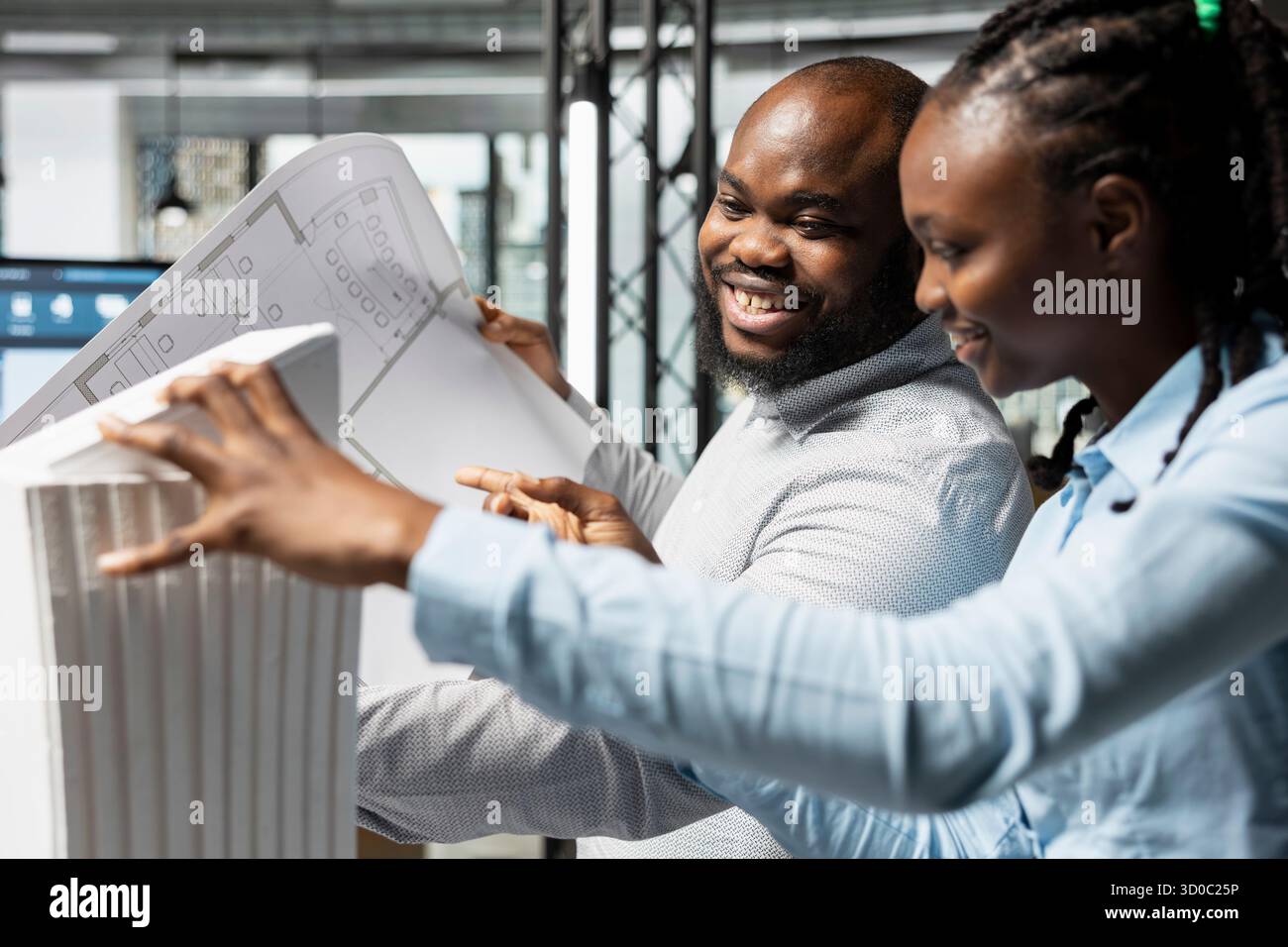 Diverse architectural team reviews 3D models and blueprints for a ...
