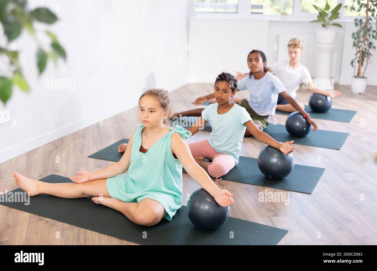 Preteen girls and boys doing core training with bender balls during ...
