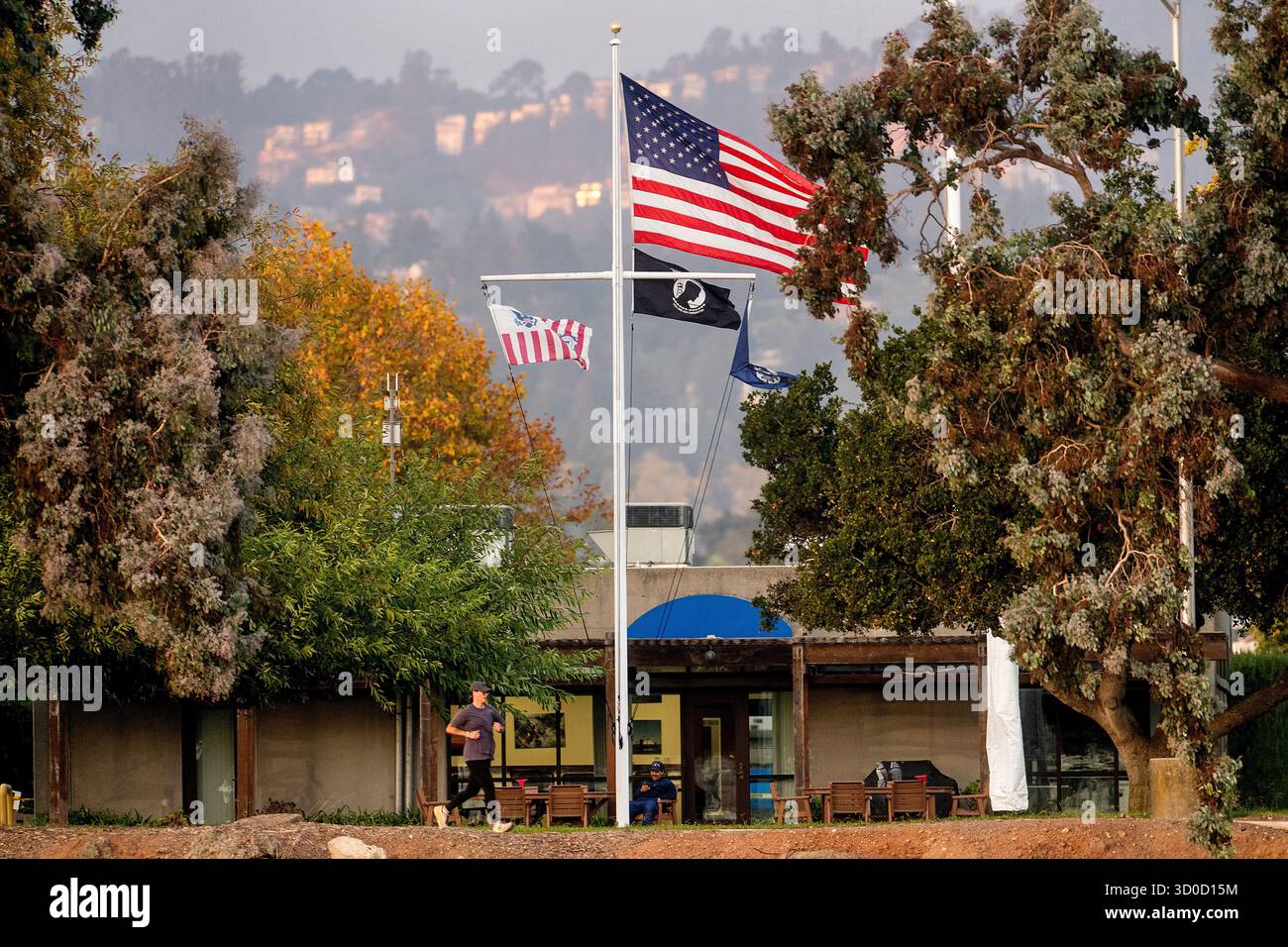A jogger passes an American flag at Coast Guard Base Alameda on ...