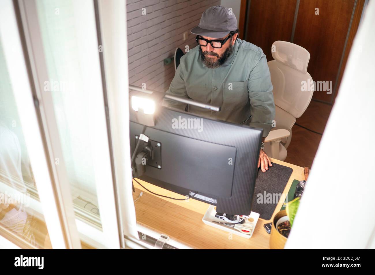 Man standing at desk working on computer Stock Photo - Alamy