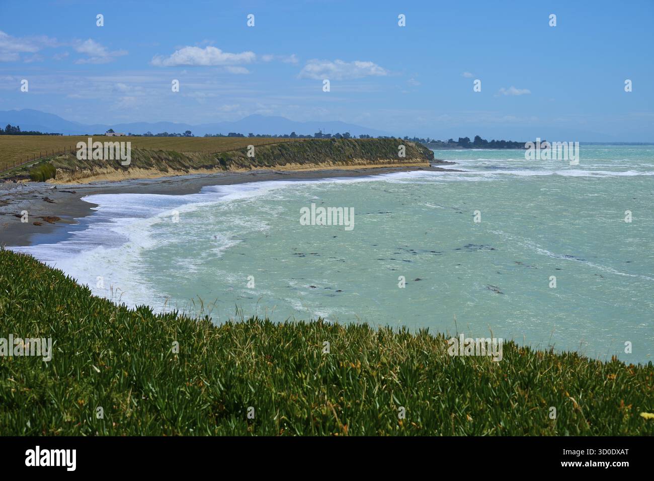 Coast with waves and distant hills under blue skies, Tuhawaiki Point ...