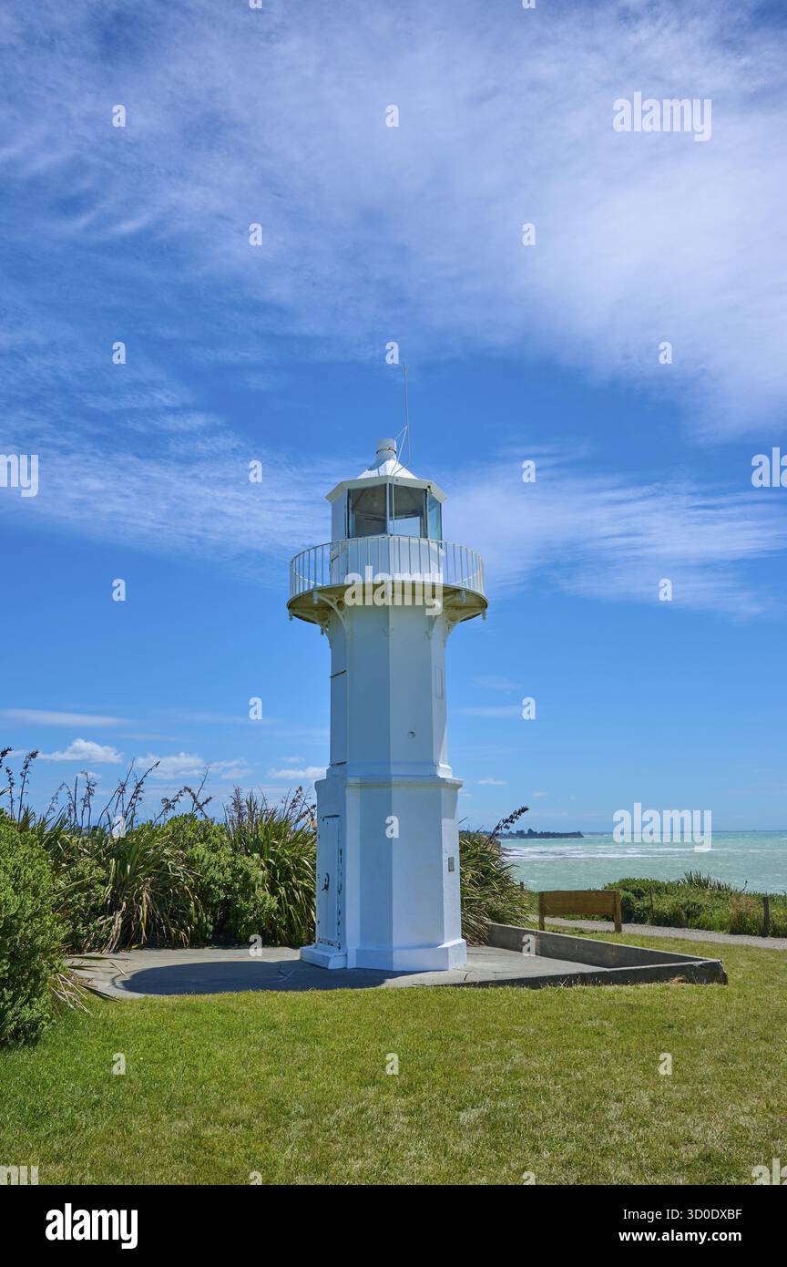 White lighthouse on the coast under blue sky, Tuhawaiki Point ...