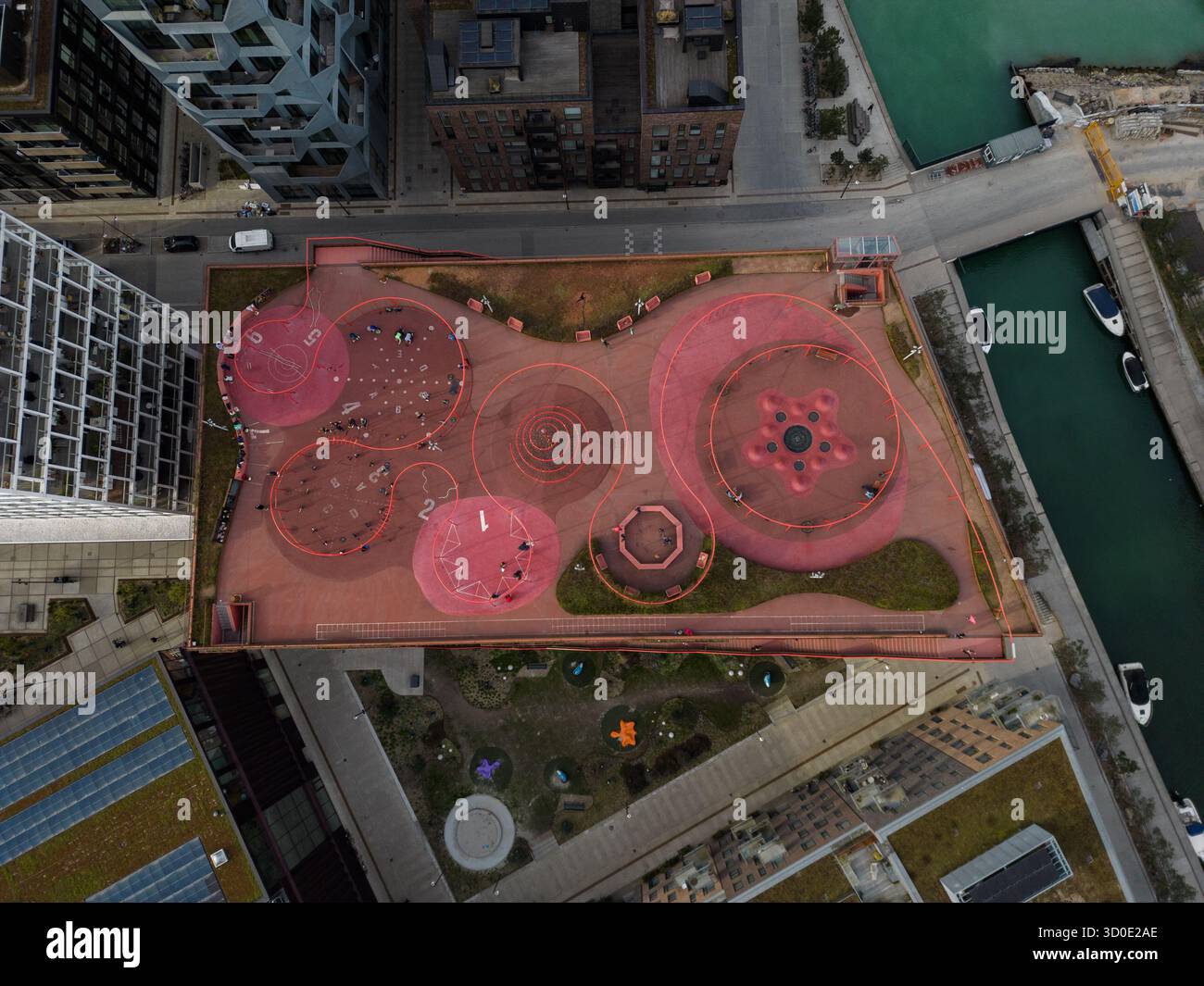 Aerial view of a vibrant red playground with playful circular designs ...