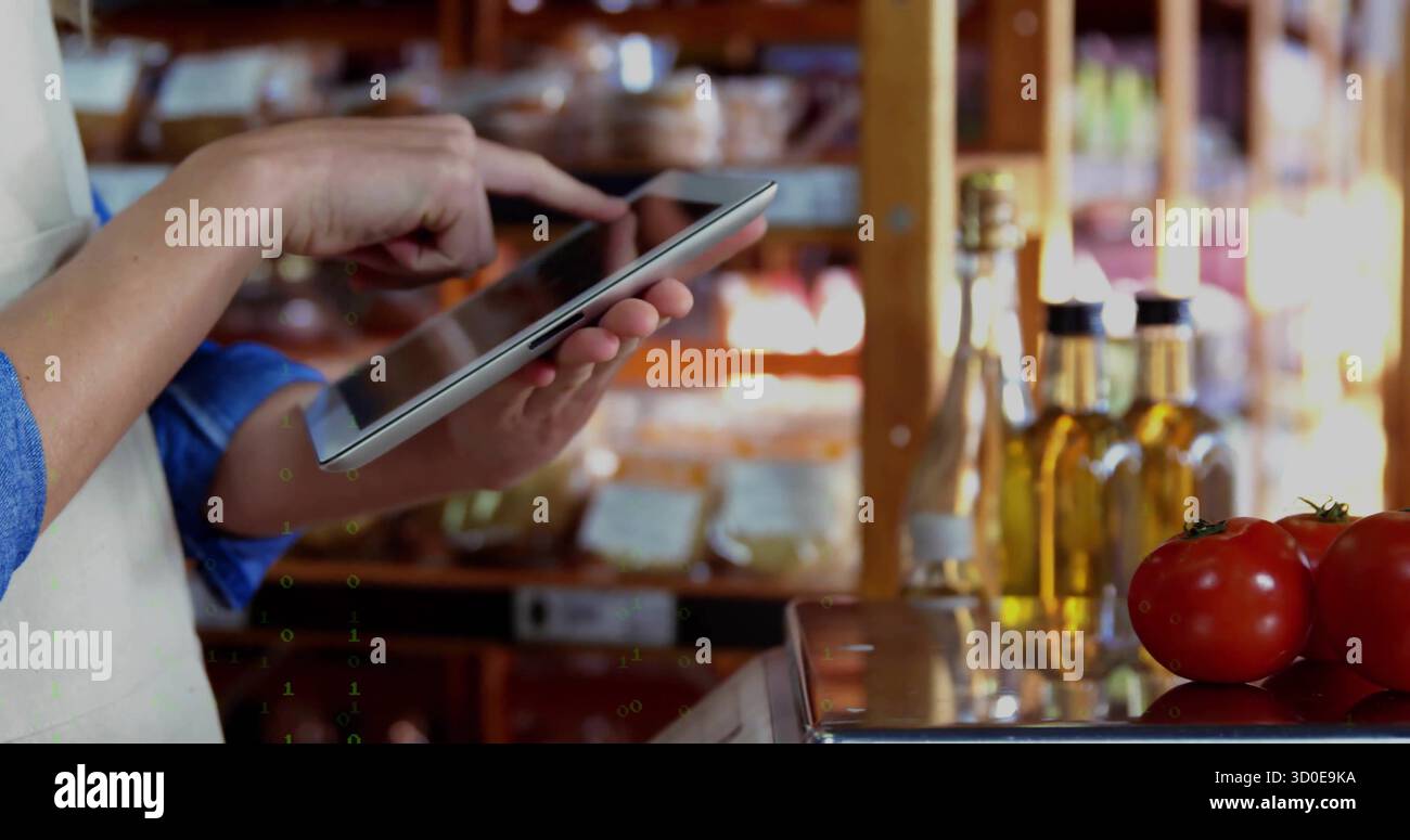 Tapping tablet shop assistant in apron at deli counter, with ripe ...