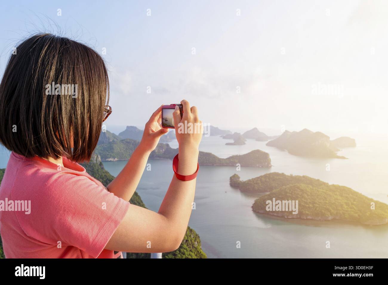 Woman tourist on peak viewpoint of Ko Wua Ta Lap island use camera take ...