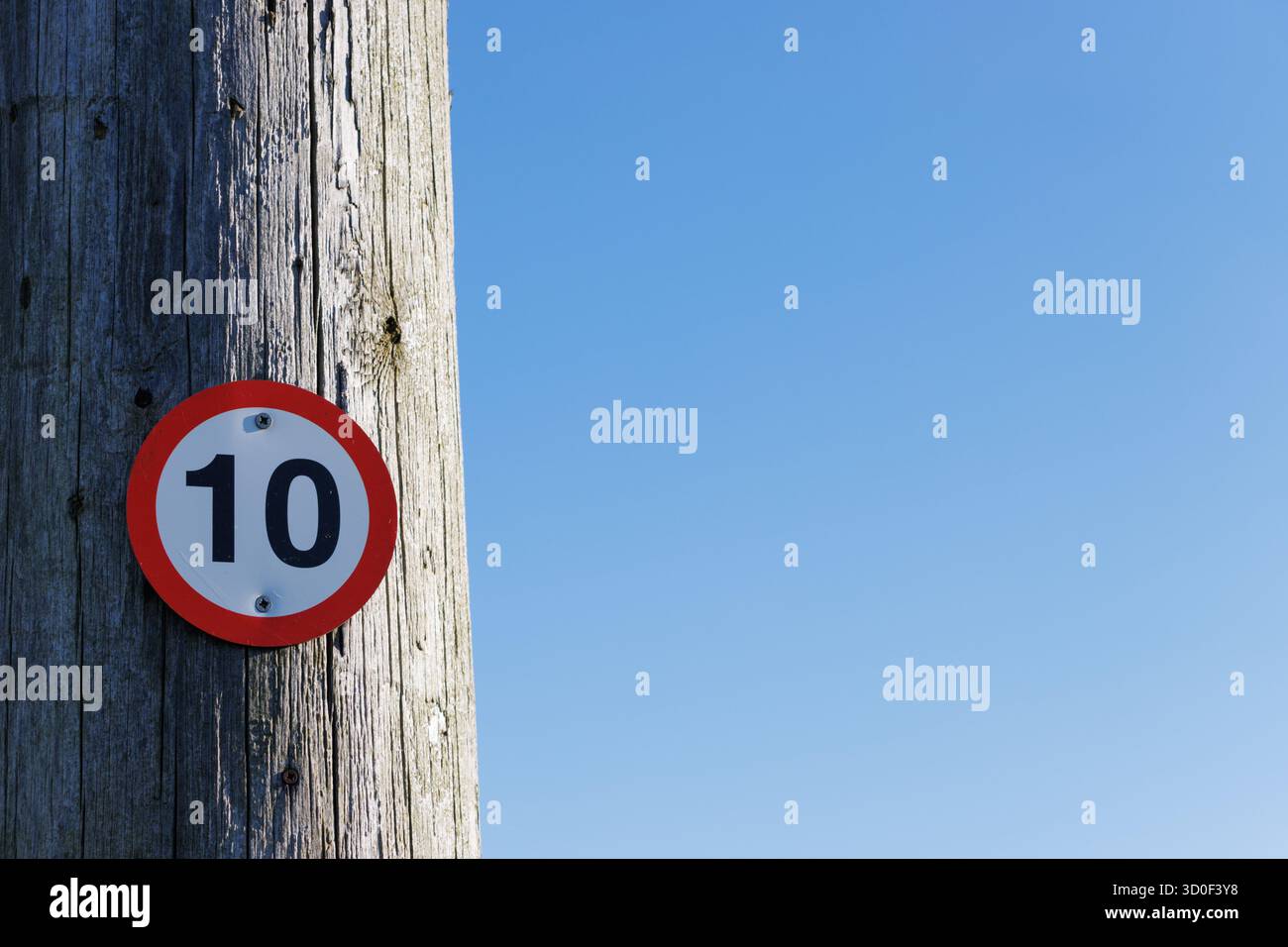 Ten mph speed limit sign on wooden pole in residential area Stock Photo ...