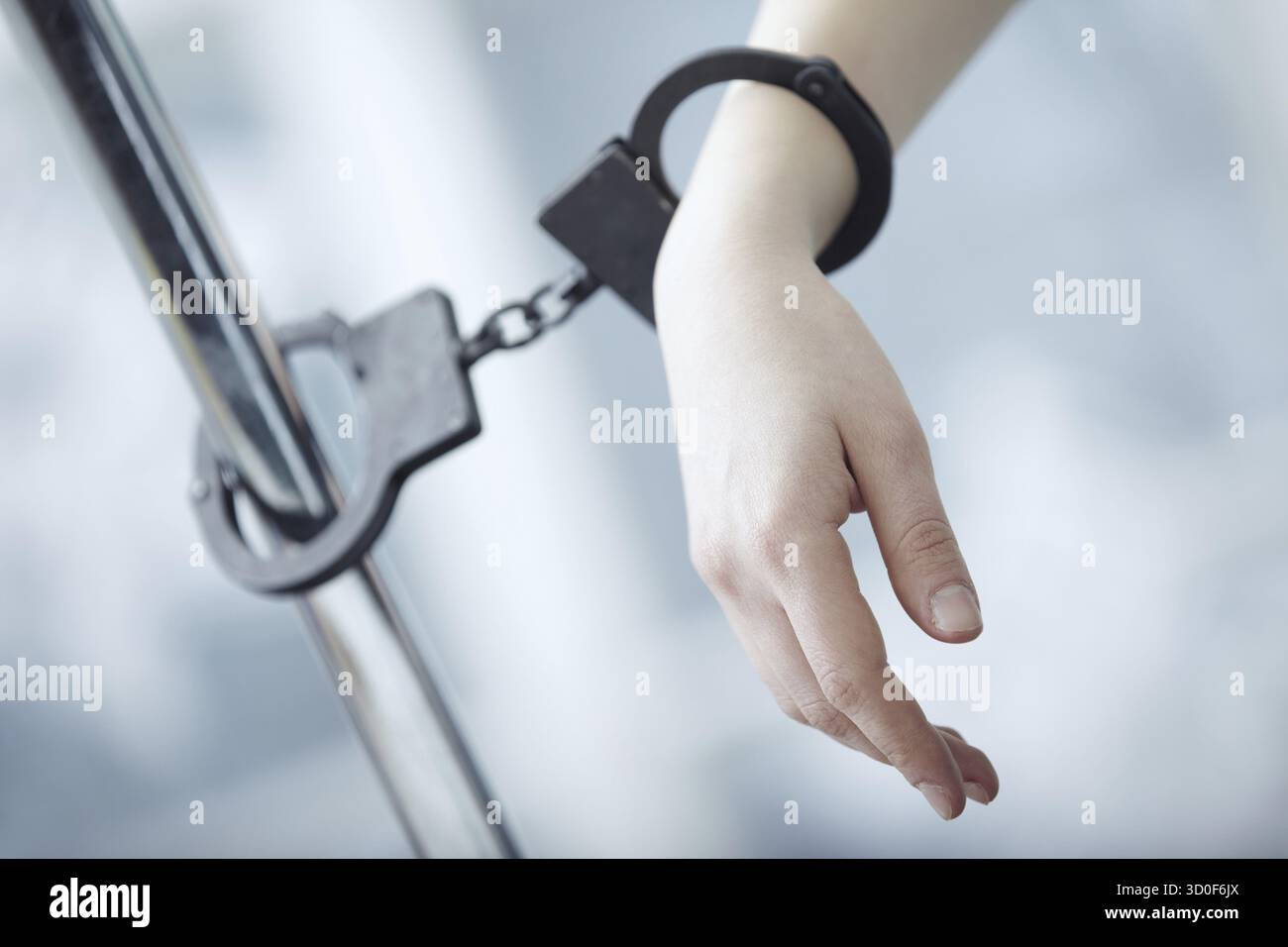 Human hand bounded to the metal pole by handcuffs Stock Photo - Alamy