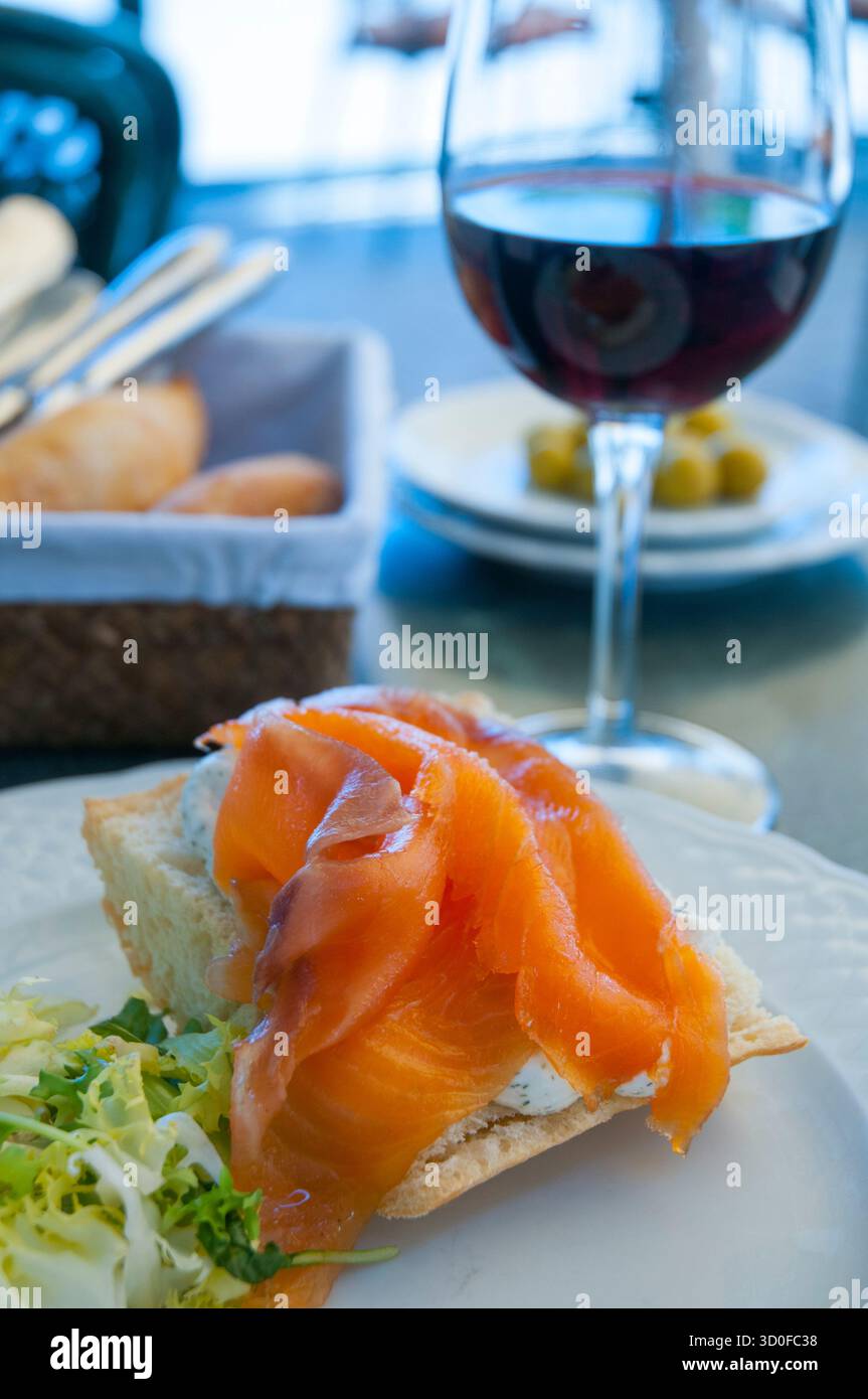 Spanish tapa: smoked salmon on toast and glass of red wine. Madrid ...