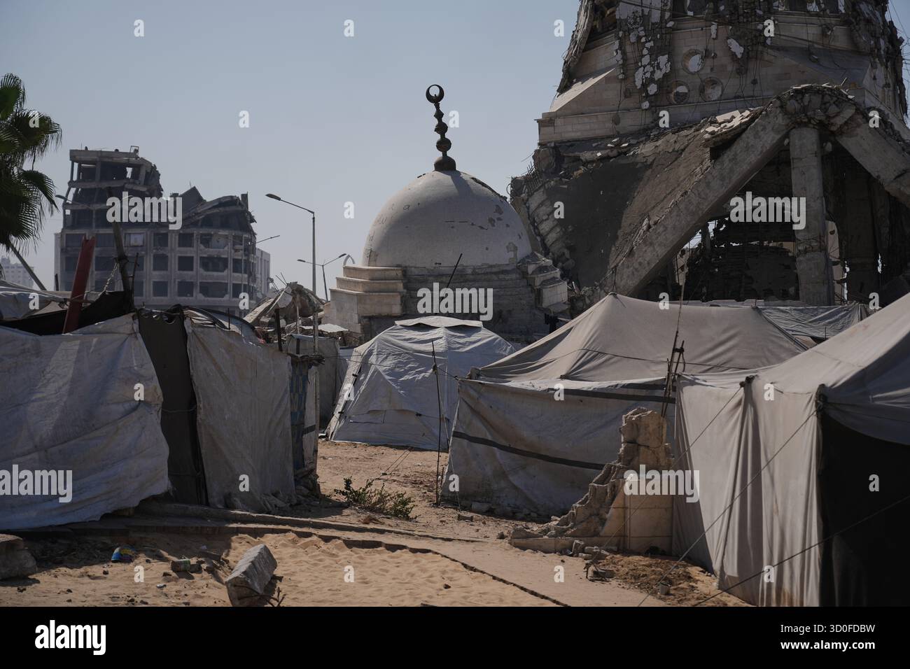 Tents sheltering displaced Palestinians stand amid the ruins of a ...
