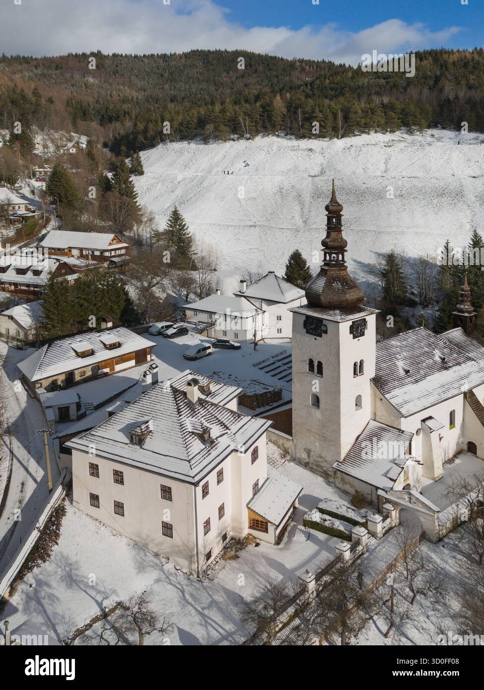Aerial view of a snow-covered village nestled at the foot of a mountain ...