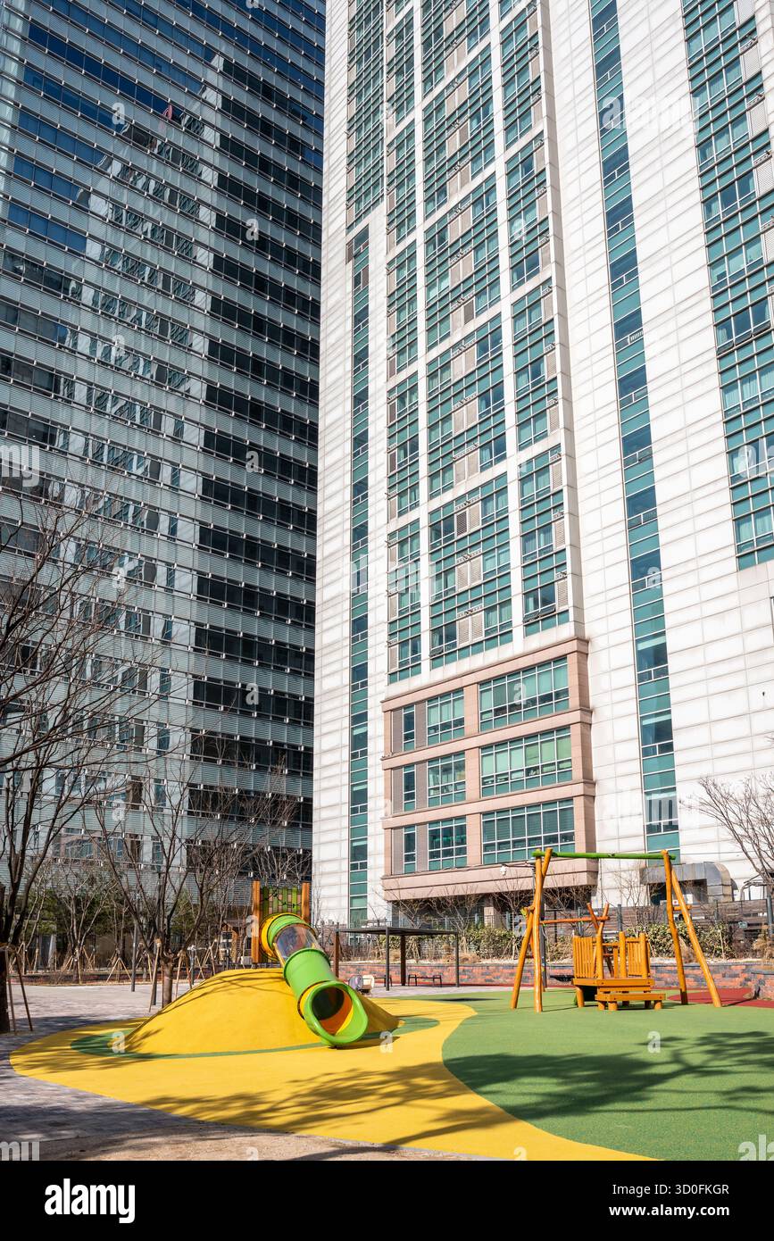 Urban playground with slides and swings near tall buildings in Seoul ...