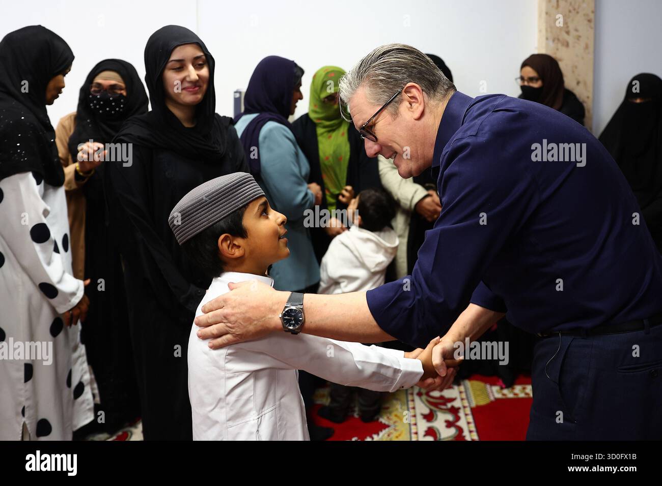 Britain's Prime Minister Keir Starmer greets a young boy as he visits ...