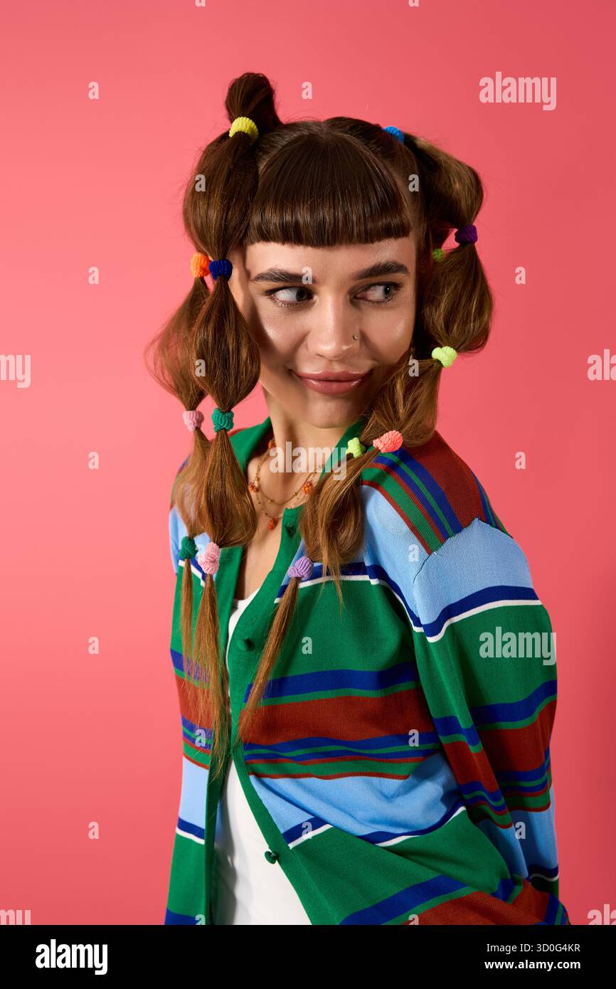 A pretty young woman features a fun hairstyle with bright pom poms ...