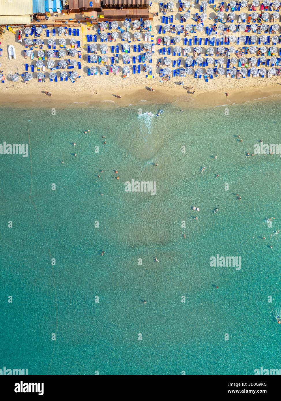 Aerial view of sun-kissed beach umbrellas line the golden sand where ...
