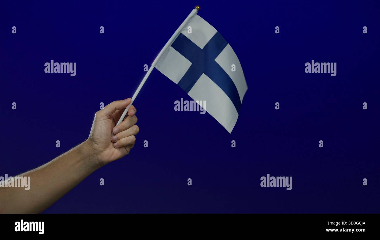 Man holding finnish flag against dark blue background symbolizes ...
