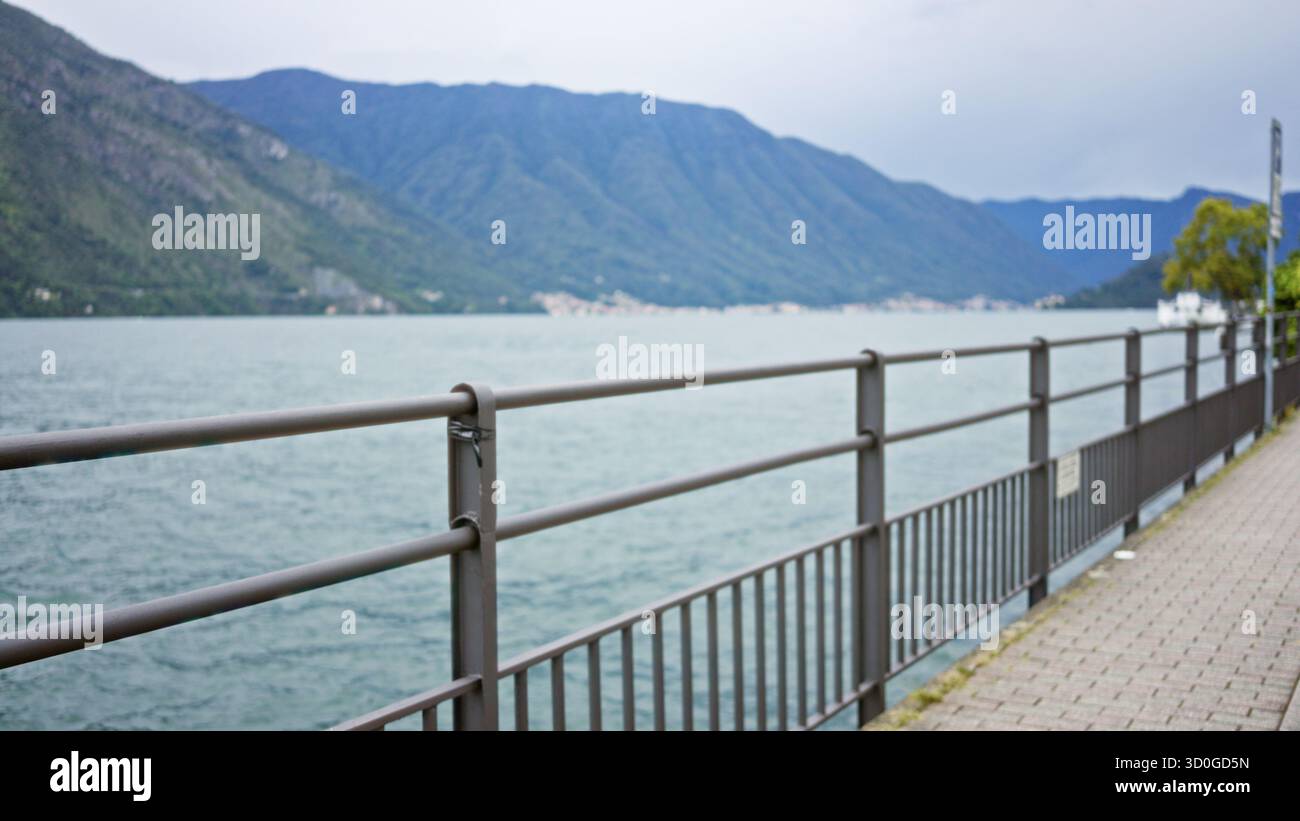 Lakeside metal railing and paved promenade captured in shallow bokeh on ...