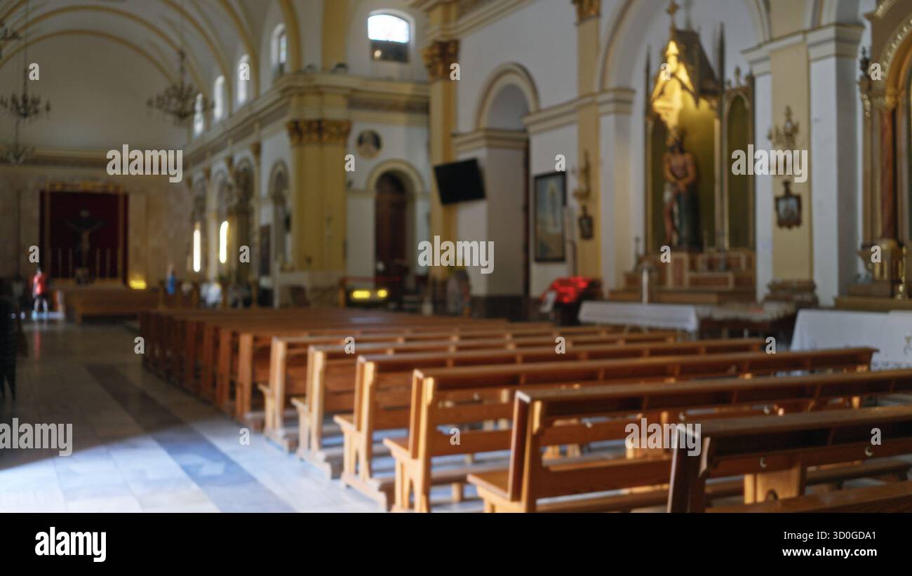 Blurry interior church nave with defocused wooden pews, altar and ...