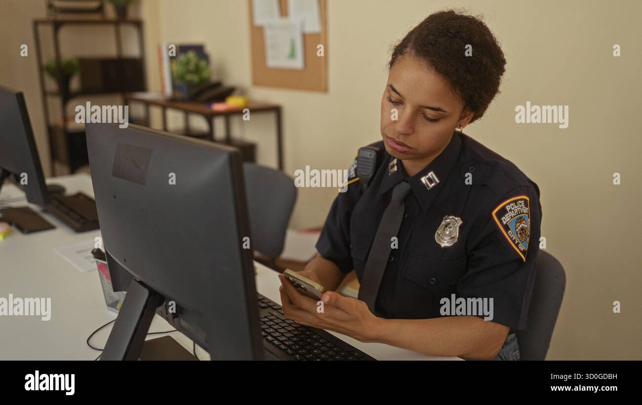 Hispanic female police officer in uniform, focused at her desk in a ...