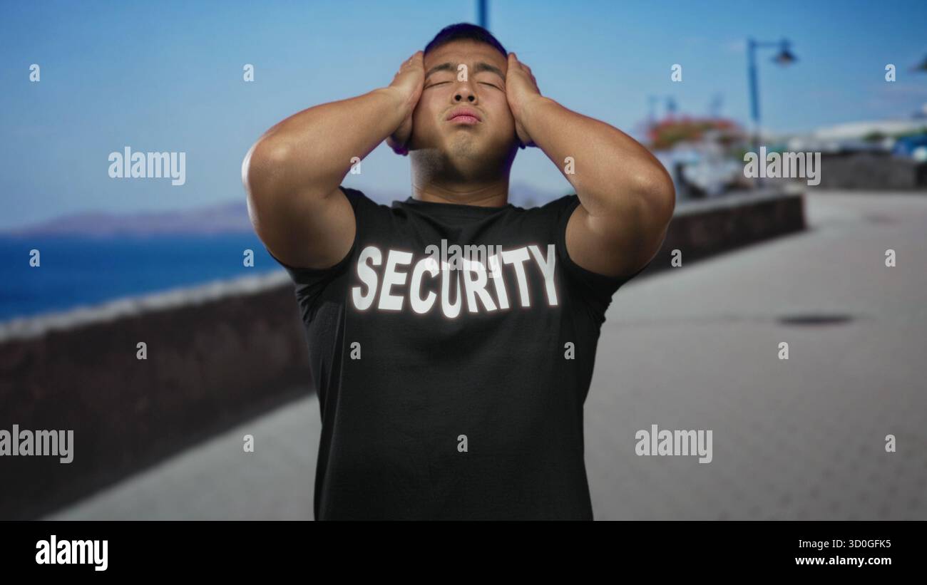 Young chinese security guard wearing a black shirt pressing both hands ...