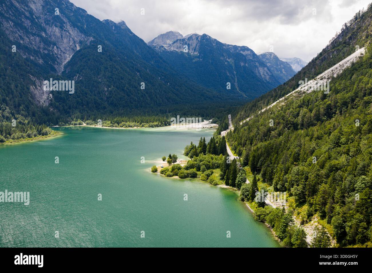 Aerial view of the serene Lago del Predil reflecting the towering ...