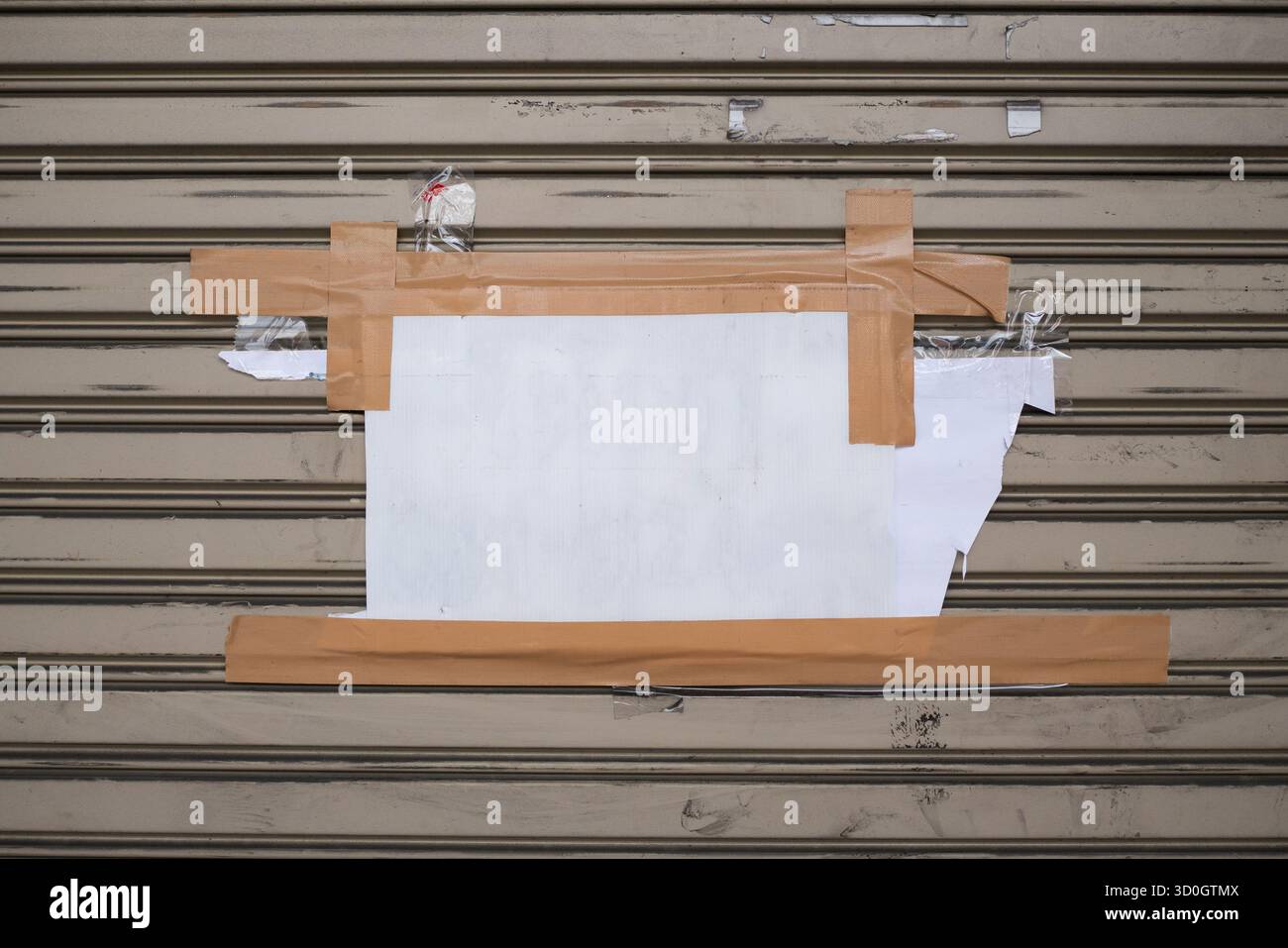White A4 paper was attach on a metal rolling shutter door with brown ...