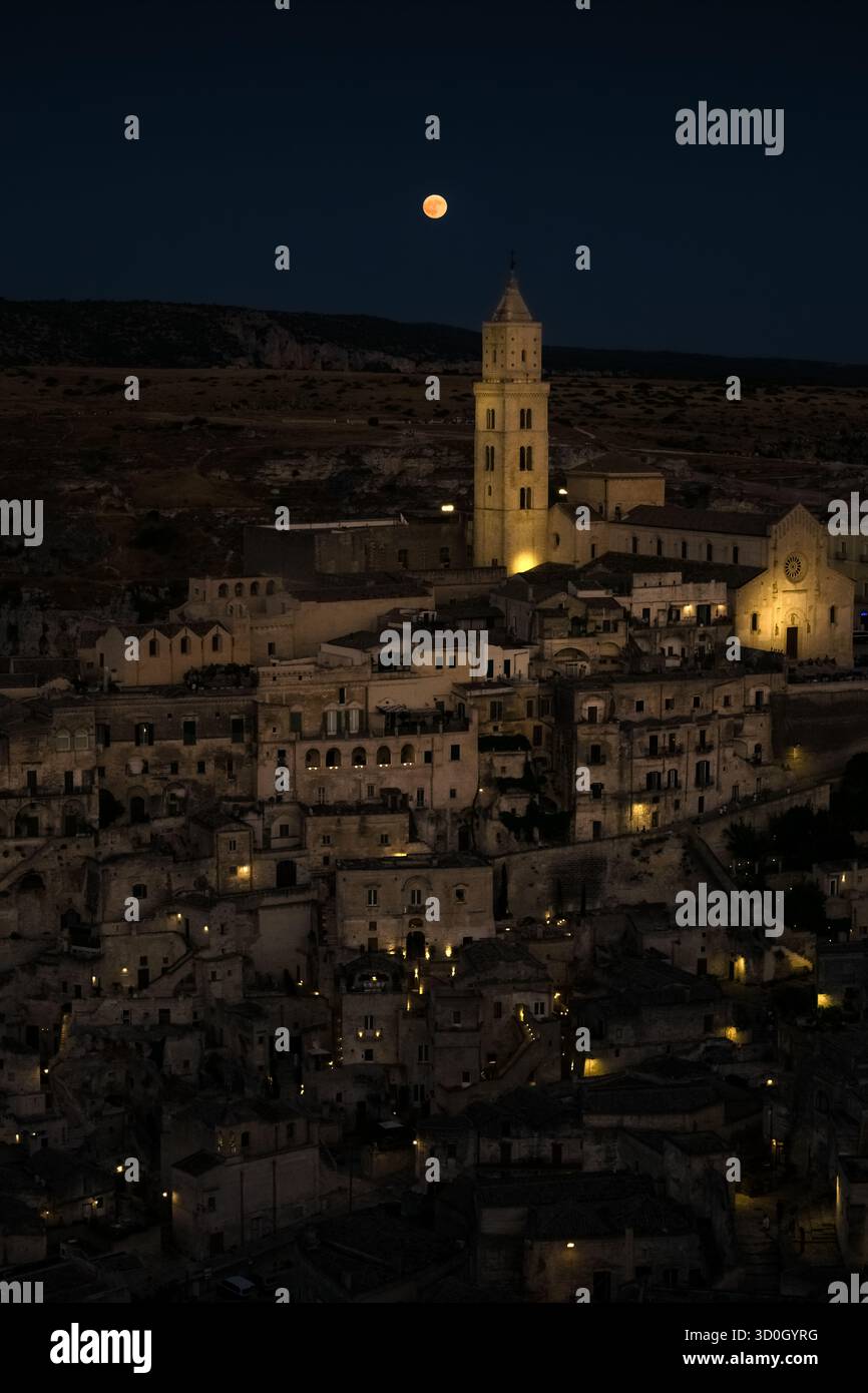 Aerial view of the Sassi di Matera glows warmly under the moon's soft ...