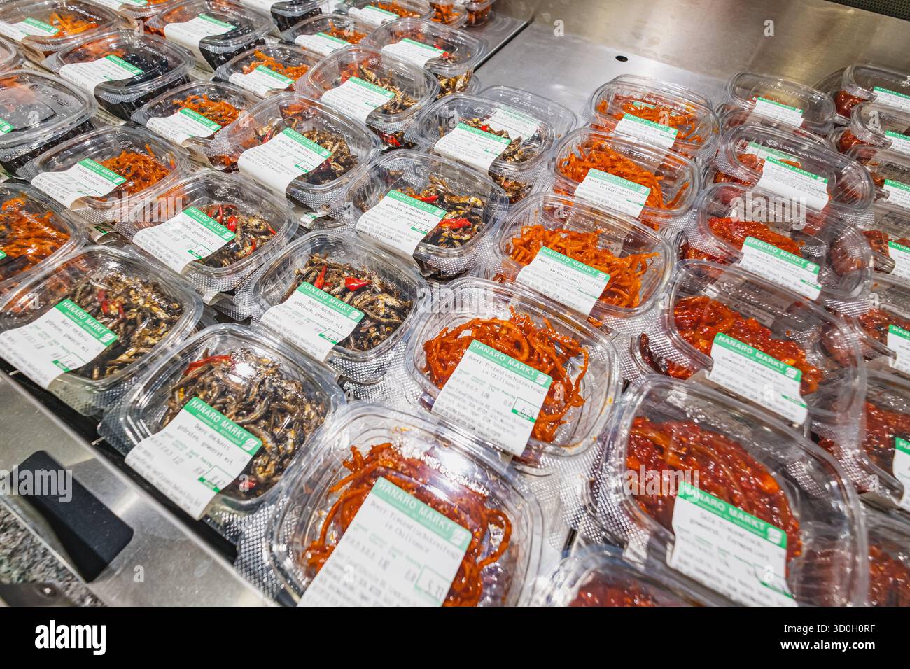 A supermarket shelf displaying various pre-packaged Asian meals in ...