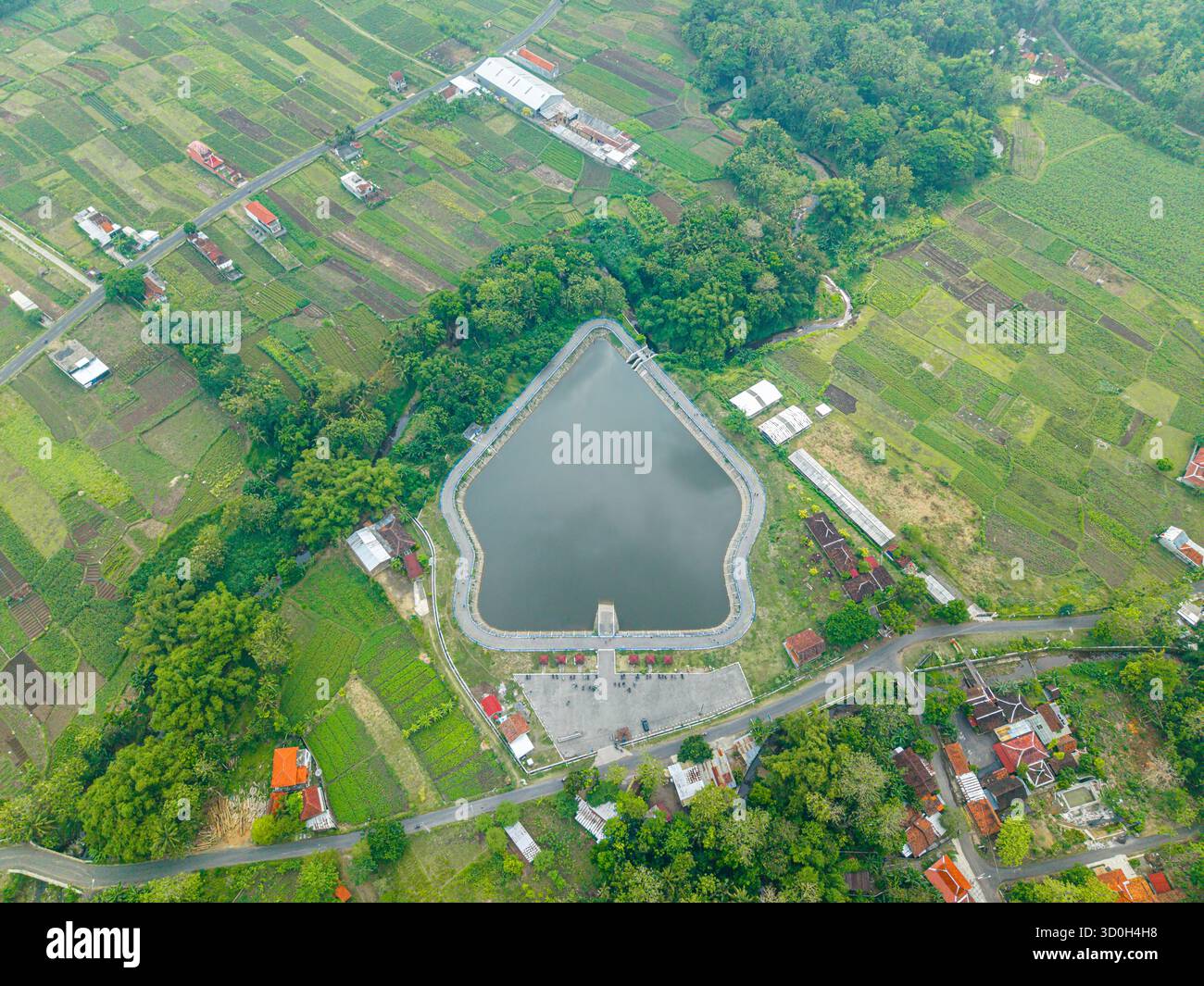 Aerial view of Embung Imogiri's dark waters contrasting with the ...