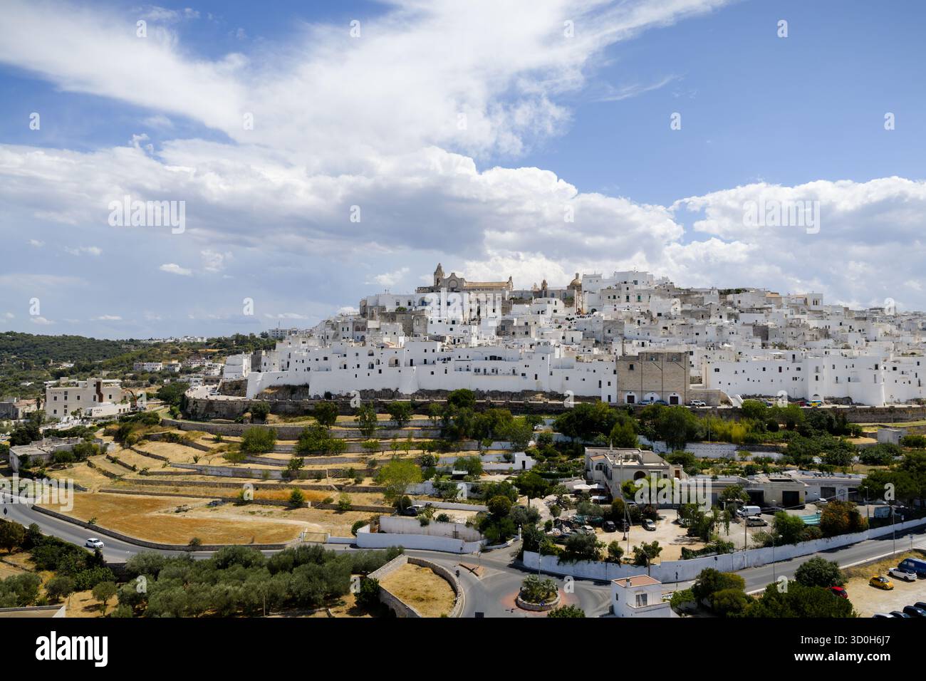 Aerial view of a brilliant white city cascading down a sun-soaked hill ...