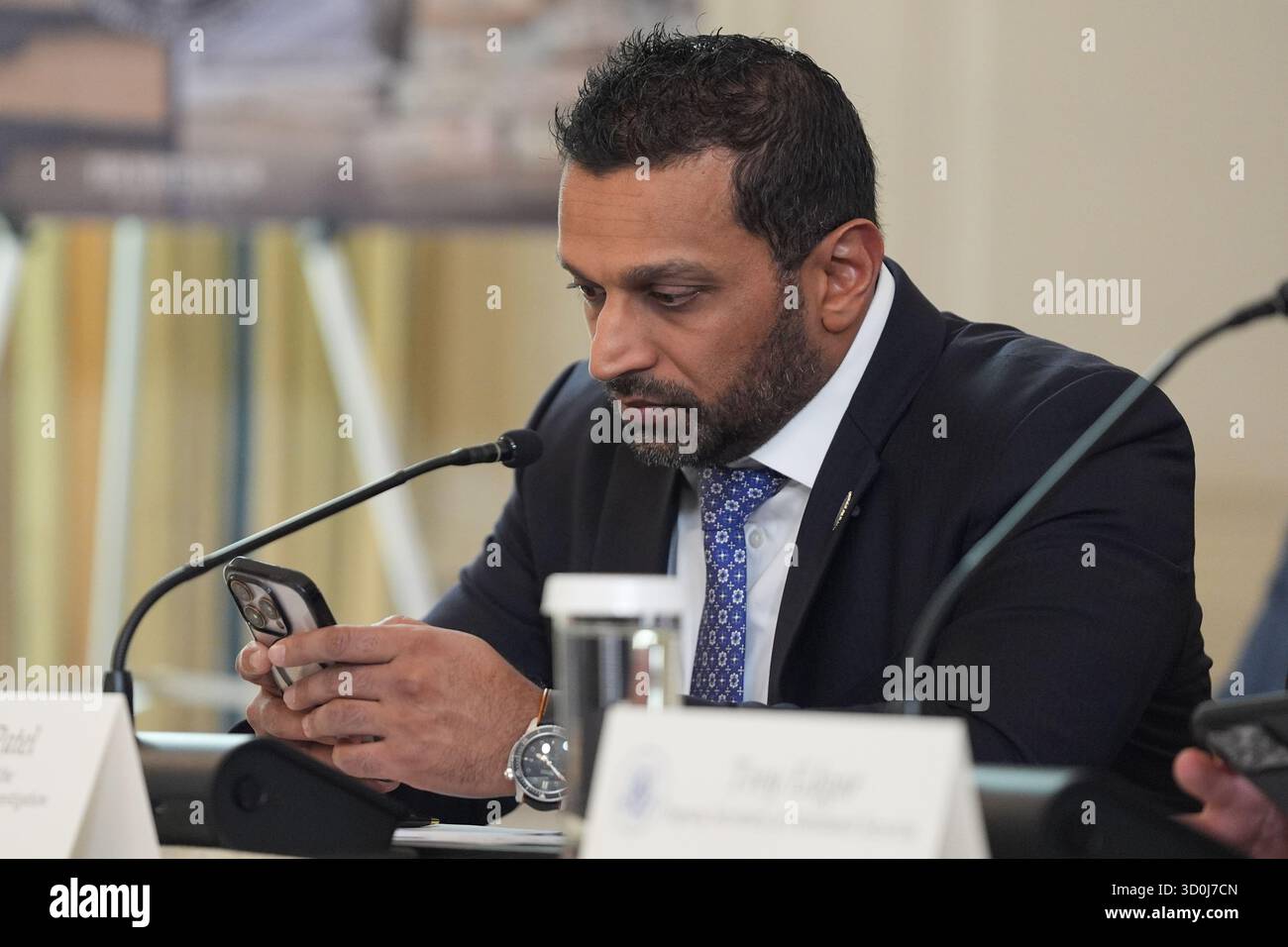 FBI director Kash Patel checks his phone before President Donald Trump ...