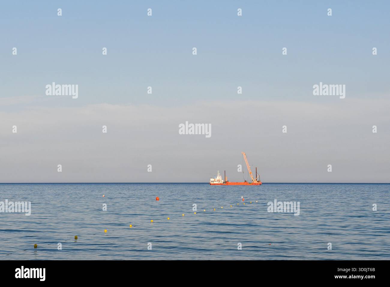 Seascape with orange crane barge used for transporting rocks for ...