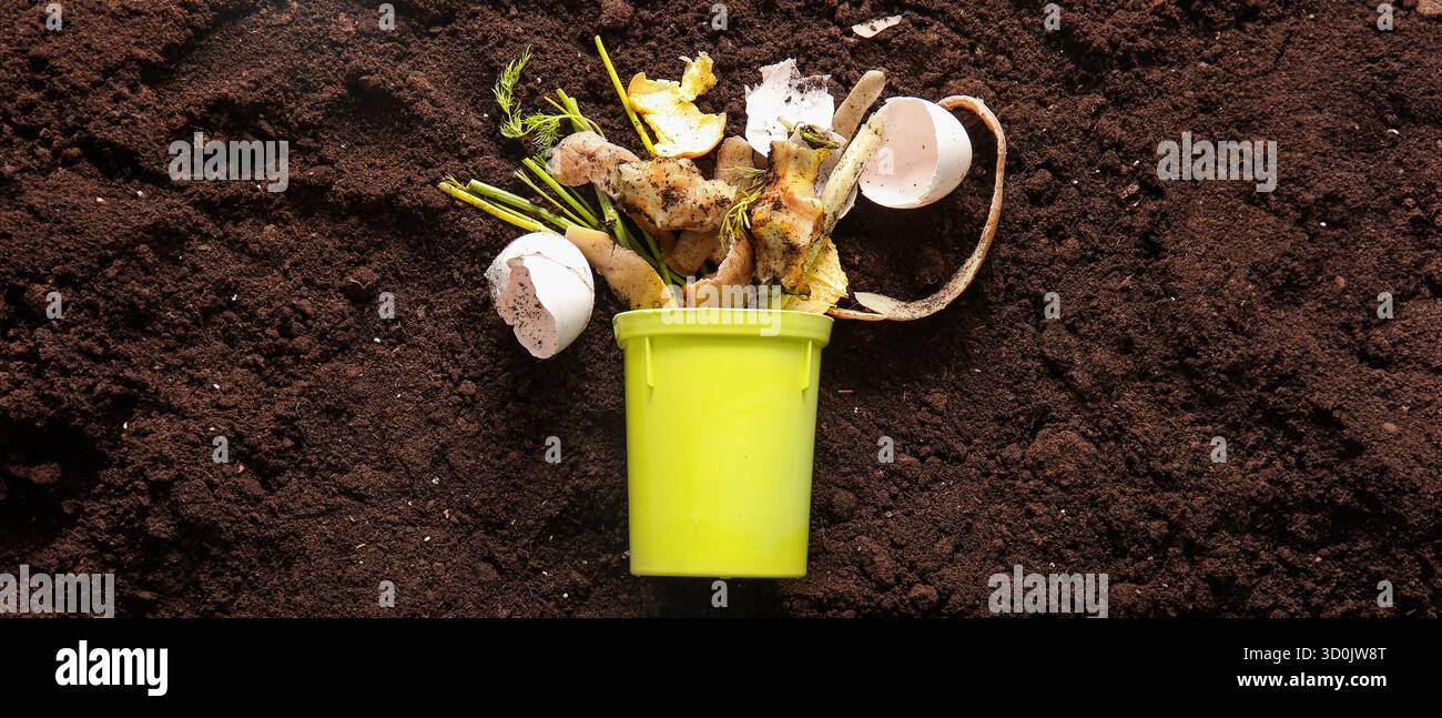 Bin with organic waste on soil. Compost recycling concept Stock Photo ...
