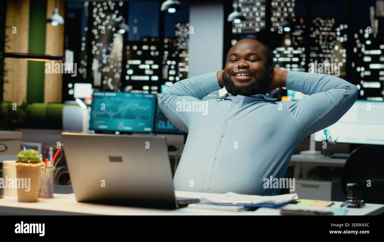 Fulfilled black businessman enjoys a quiet moment of downtime in modern ...