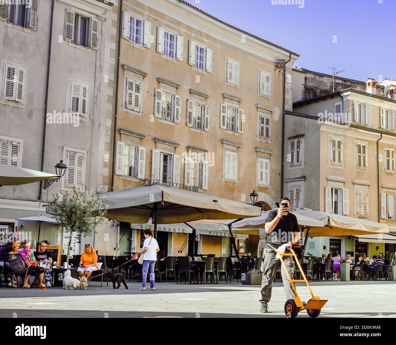A lone delivery man walks across center of sleepy seaside town of ...