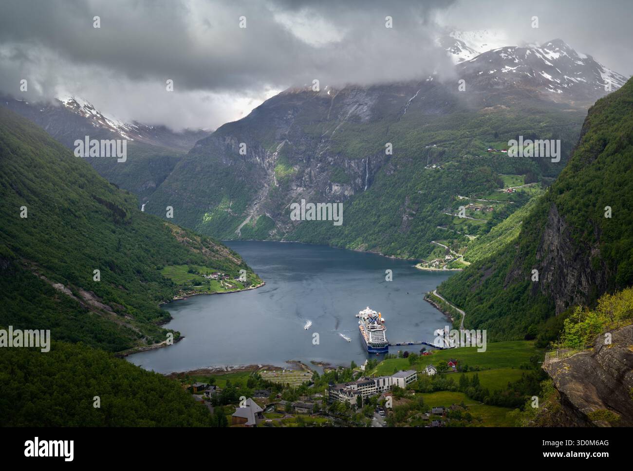 Cruise ship rests at Geirangerfjord port beneath dramatic fjord Stock ...