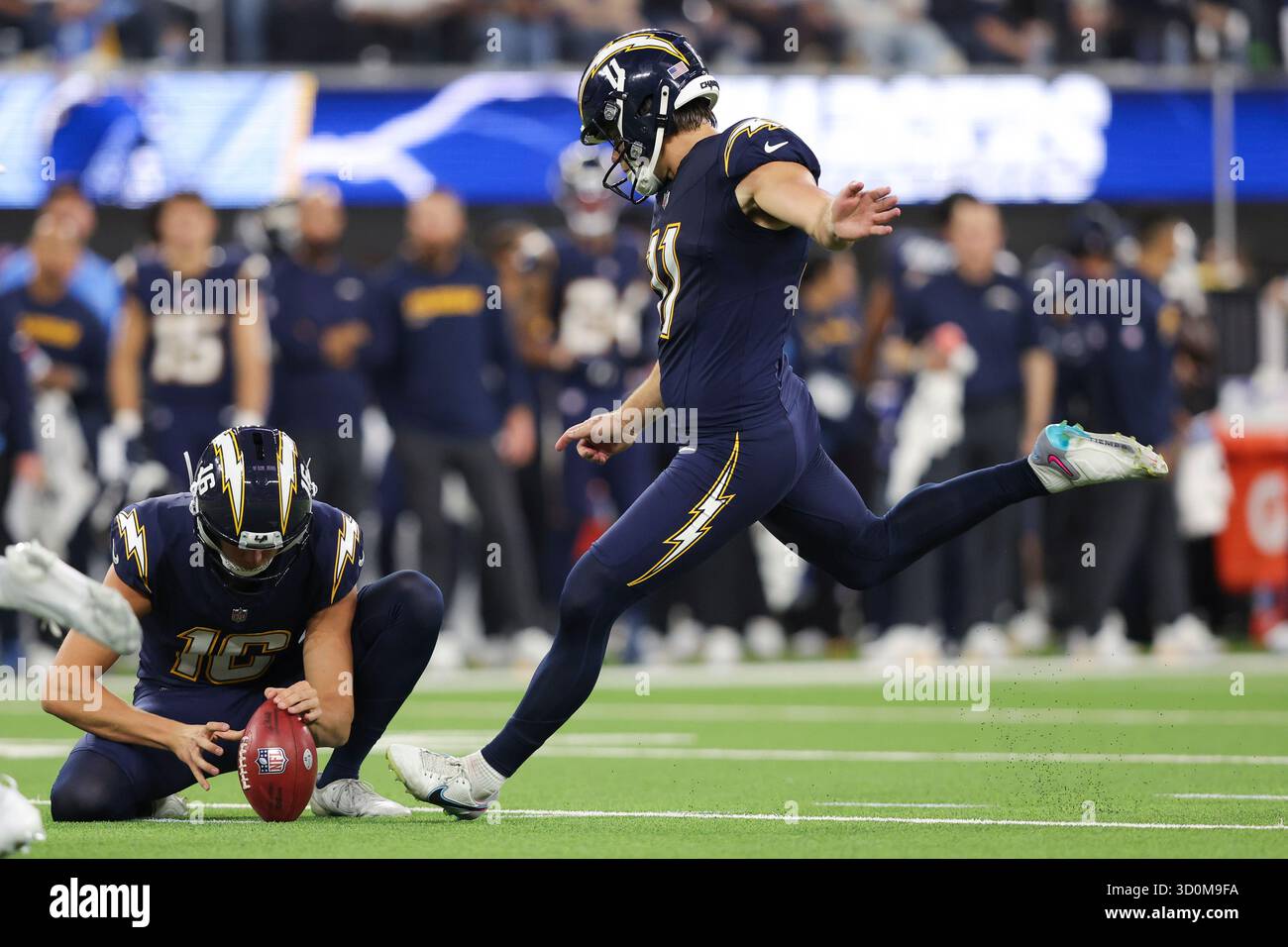 Los Angeles Chargers place kicker Cameron Dicker, right, prepares to ...