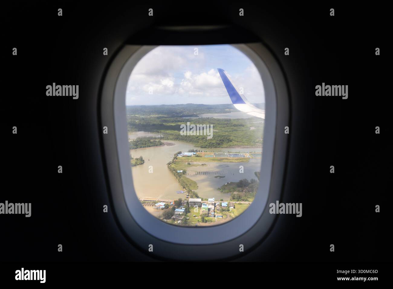 airplane window view of land and water upon takeoff image is taken at ...