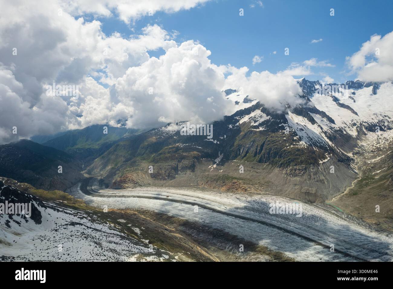 Aerial view of a vast, icy glacier snaking through a valley ...