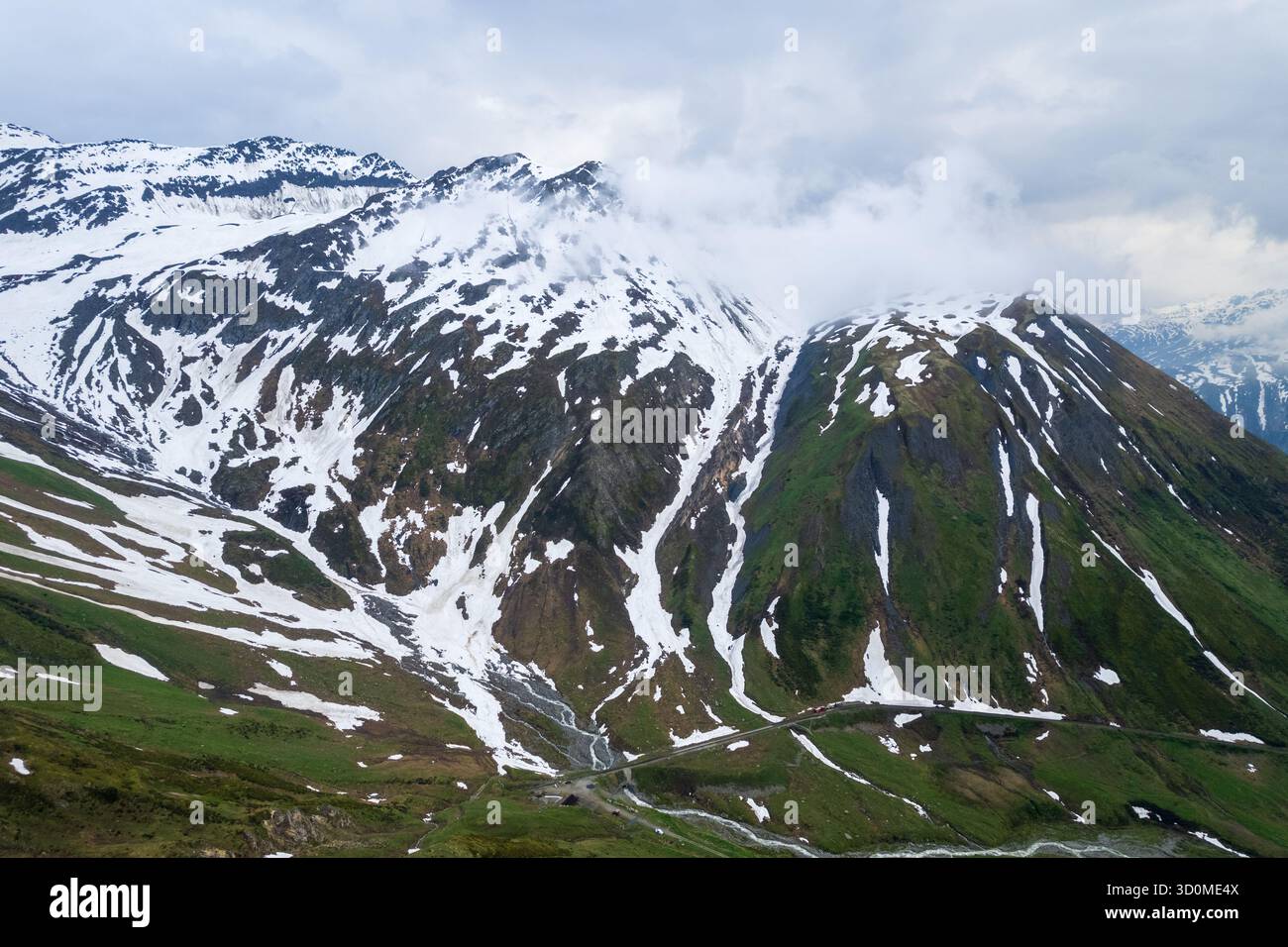 Aerial view of snow-capped peaks pierce the sky, their stark white ...