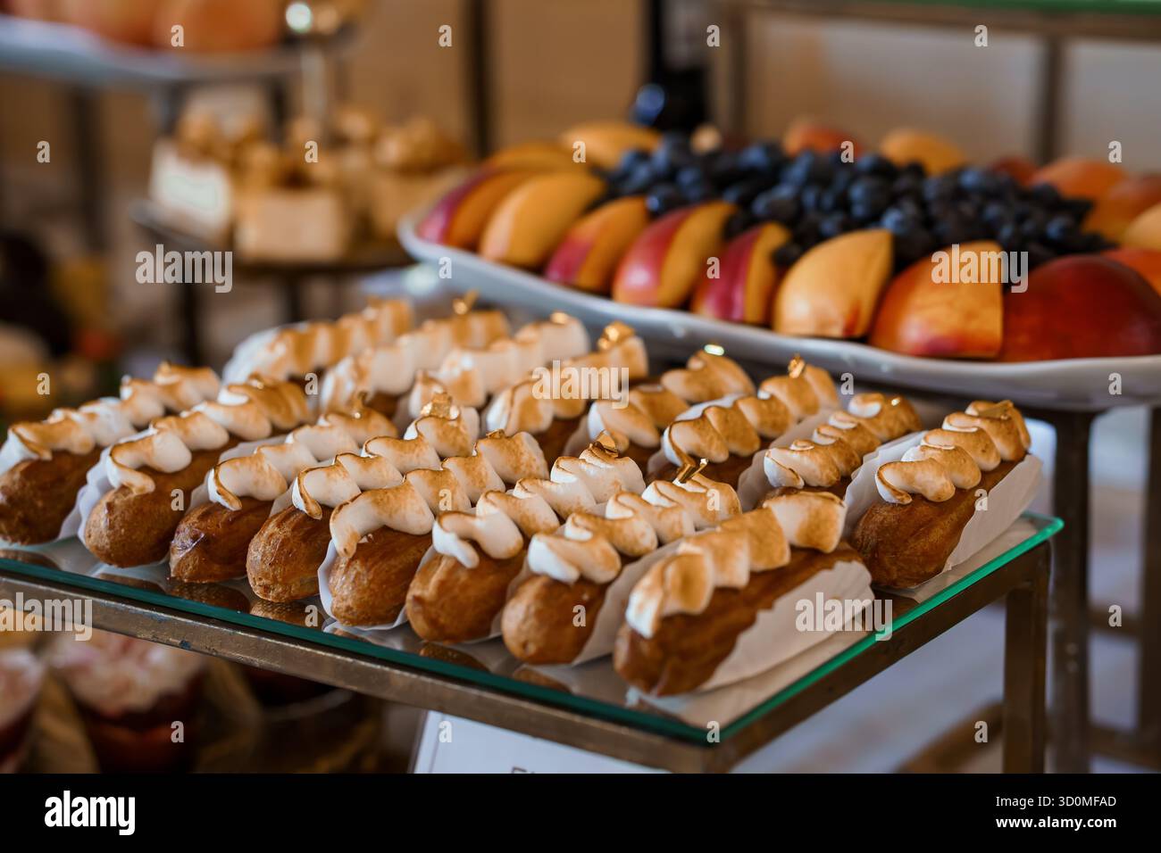 A close-up showcases a lavish dessert buffet featuring rows of cream ...