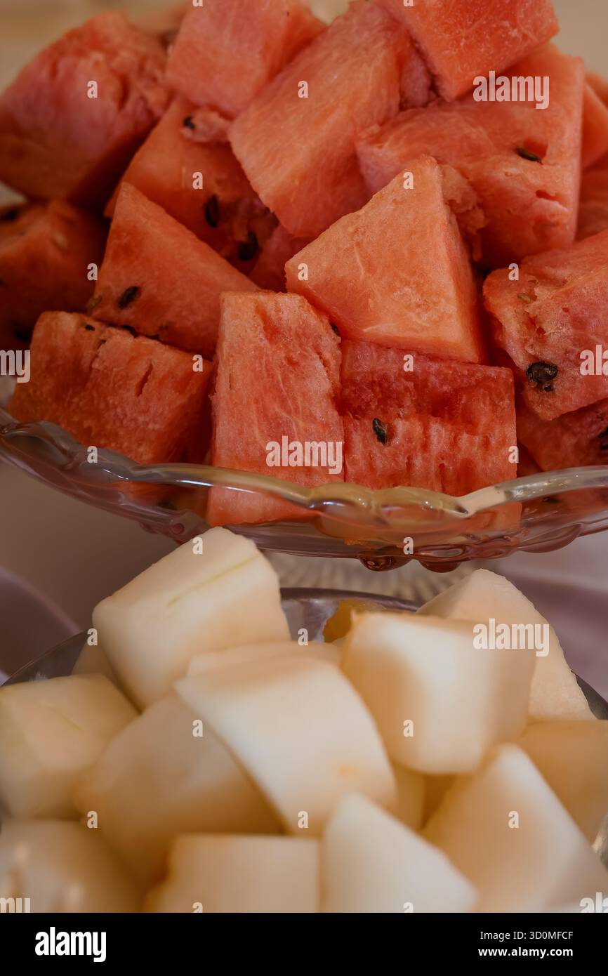 A close-up shot showcases a glass bowl filled with freshly cubed ...