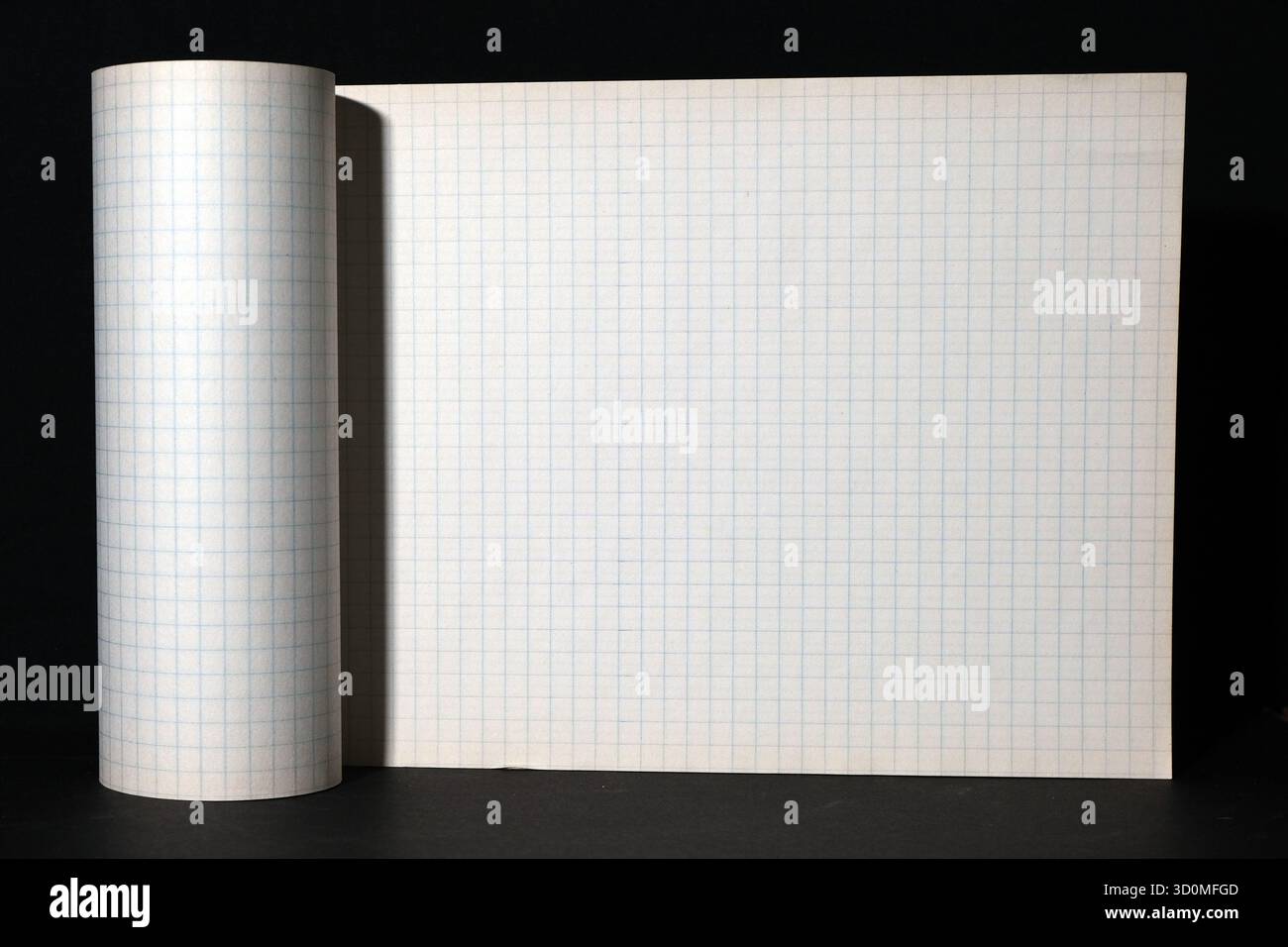 A piece of blank engineering or graph paper (quadrille paper) partially ...